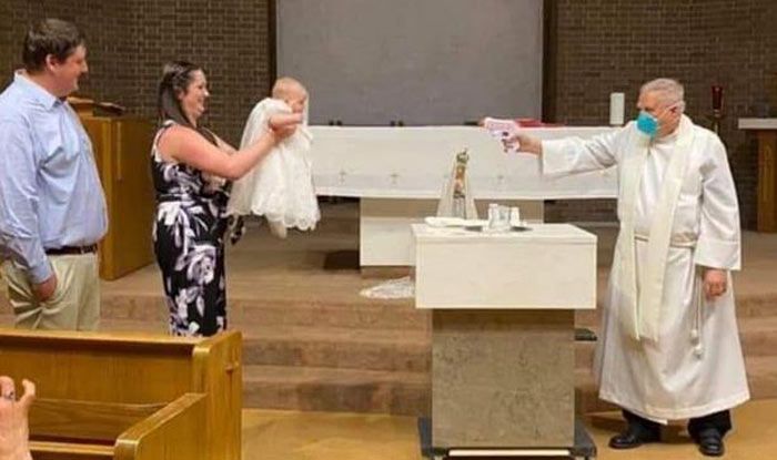 Priest performs socially-distanced baptism on baby using water pistol